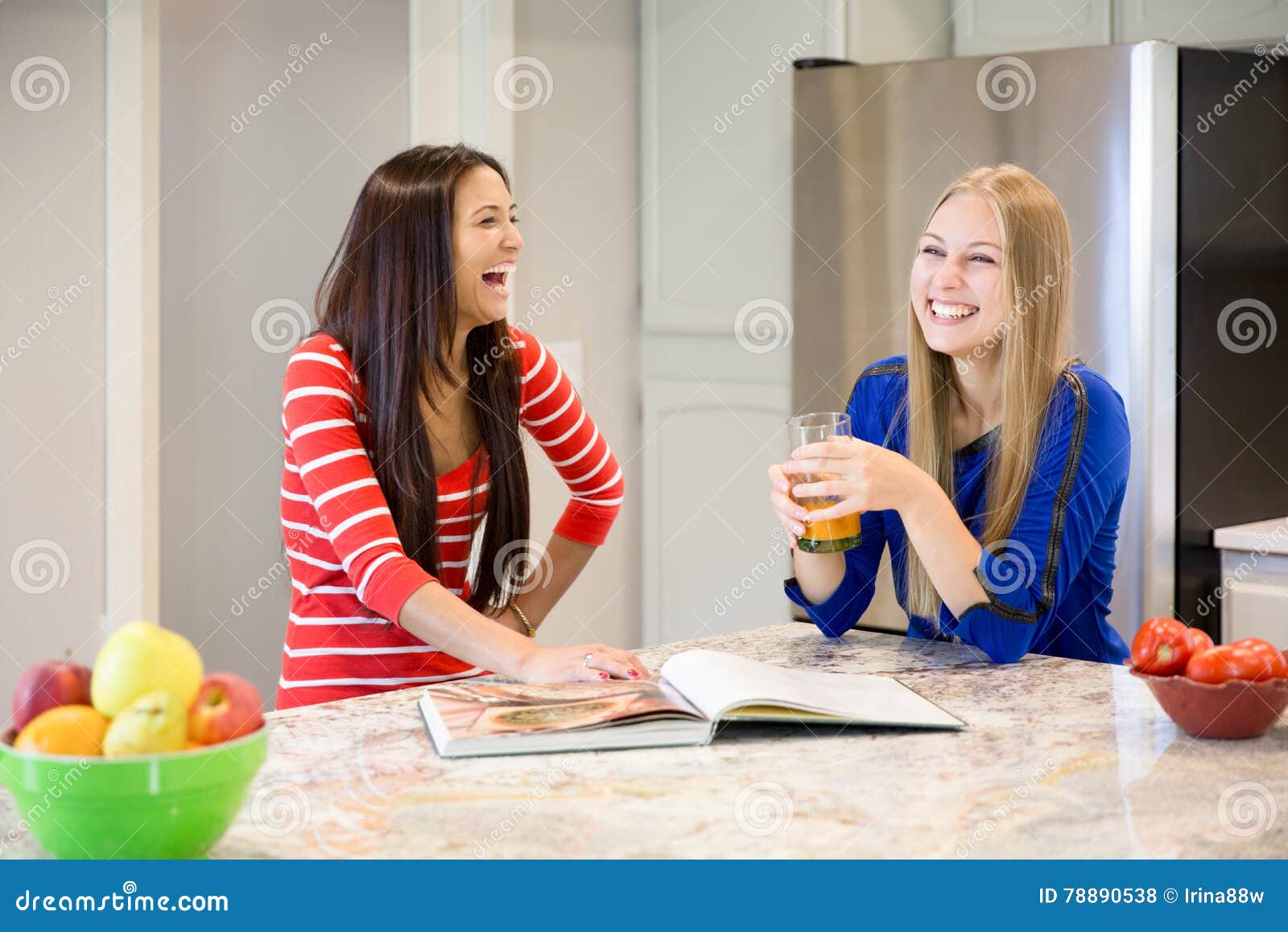 Two Beautiful Girls Laughing and Talking in the Kitchen Stock Photo ...