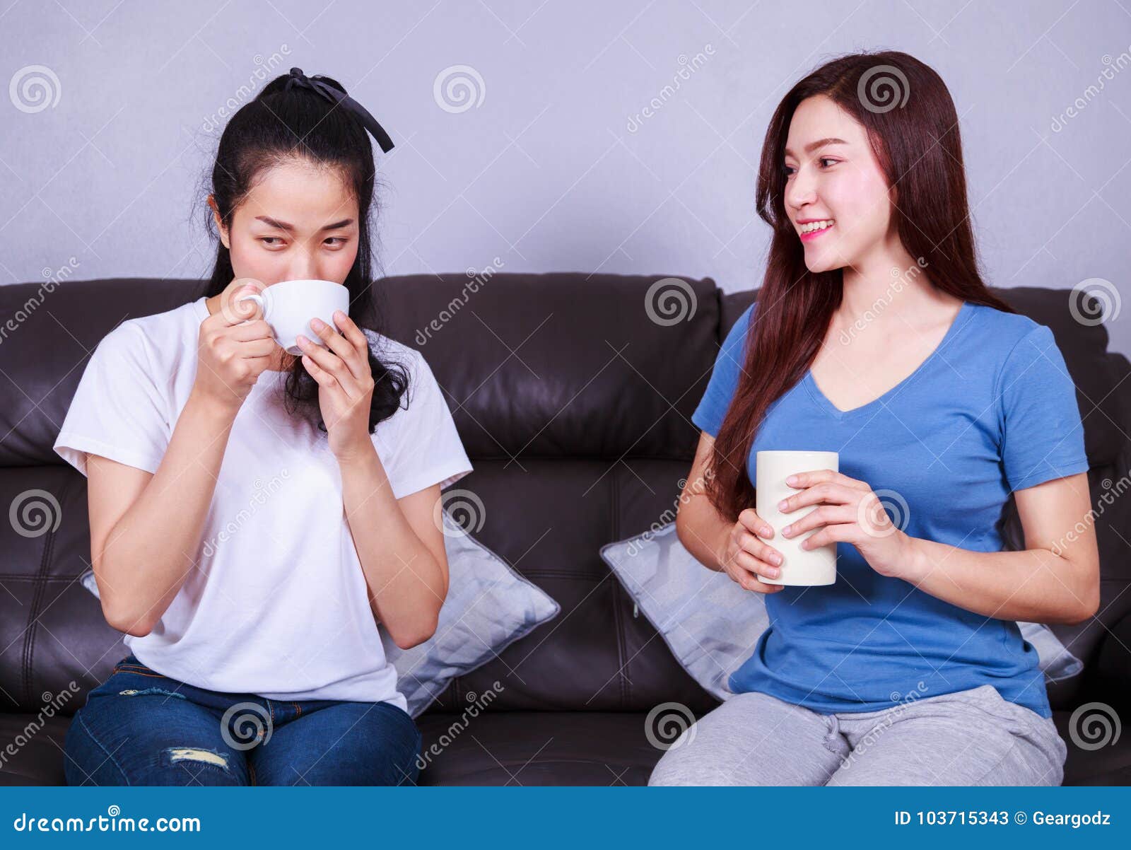 Two Best Friends Talking and Drinking a Cup of Coffee on Sofa in Stock ...