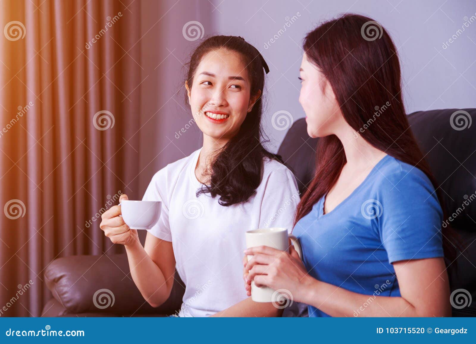 Two Best Friends Talking and Drinking a Cup of Coffee on Sofa at Stock ...