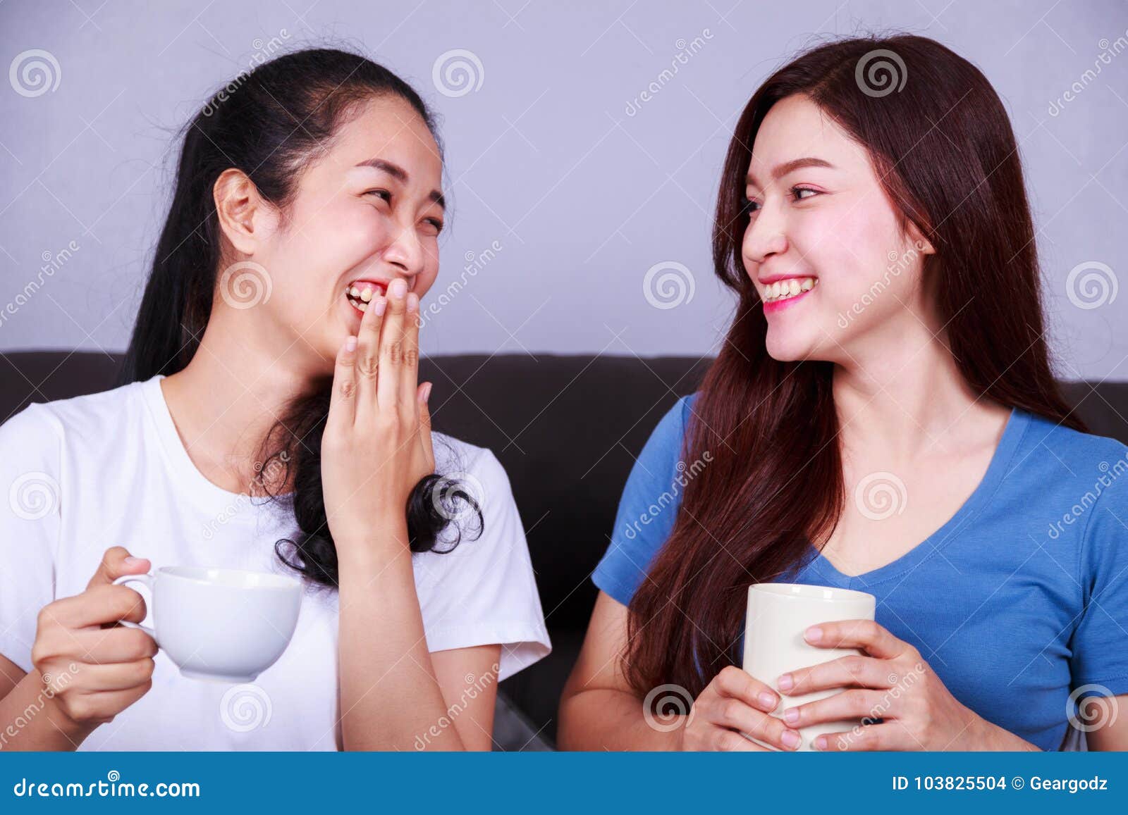 Two Best Friends Talking and Drinking a Cup of Coffee on Sofa in Stock ...