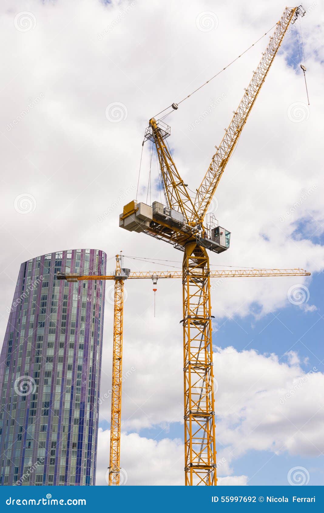Two Big Construction Cranes with Skyscraper and Cloudy Sky Stock Photo ...