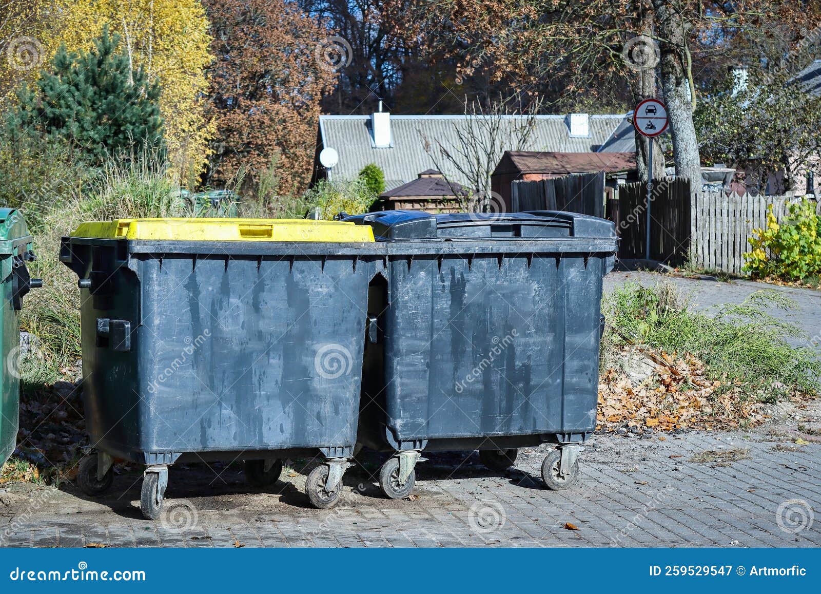 Two Black Garbage Containers on Wheels Standing on Pathway in Autumn ...