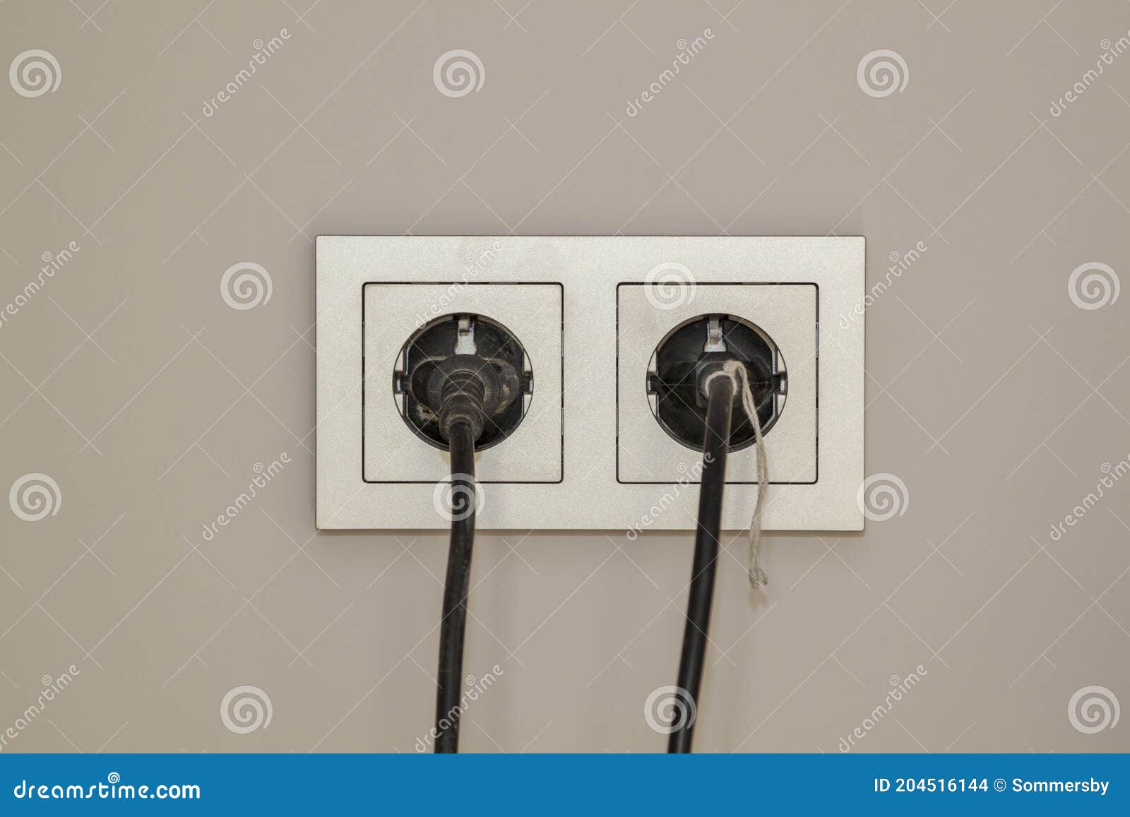 Two Black Plugs are Plugged into Double Electrical Outlet with Frame ...