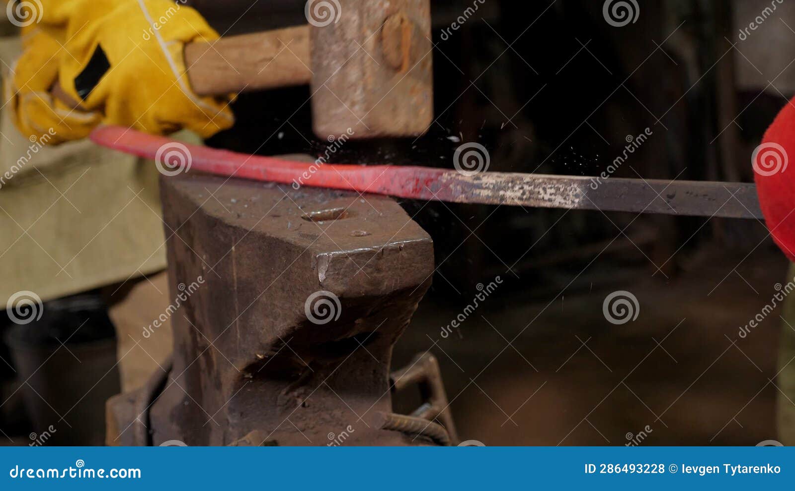 Two Blacksmiths are Beating with Hammers on Hot Metal on an Anvil in ...