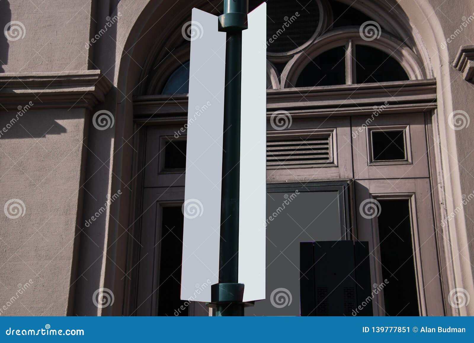 Two Blank Vertical White Signs on a Pole in Front of a Stone Building ...