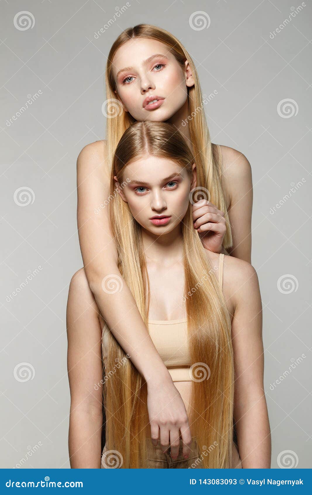 Two Blonde Beautiful Girls With Long Hair Looking At Camera In The
