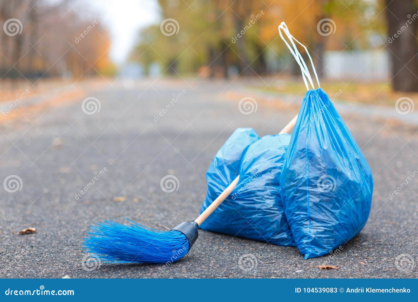 Two Packages of Garbage with a Broom Pack on the Road in the Park. Side ...