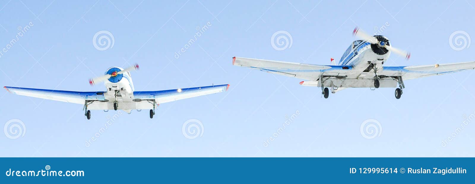 Two Blue-and-white Aircraft with Propellers Flying Next To Each Other ...