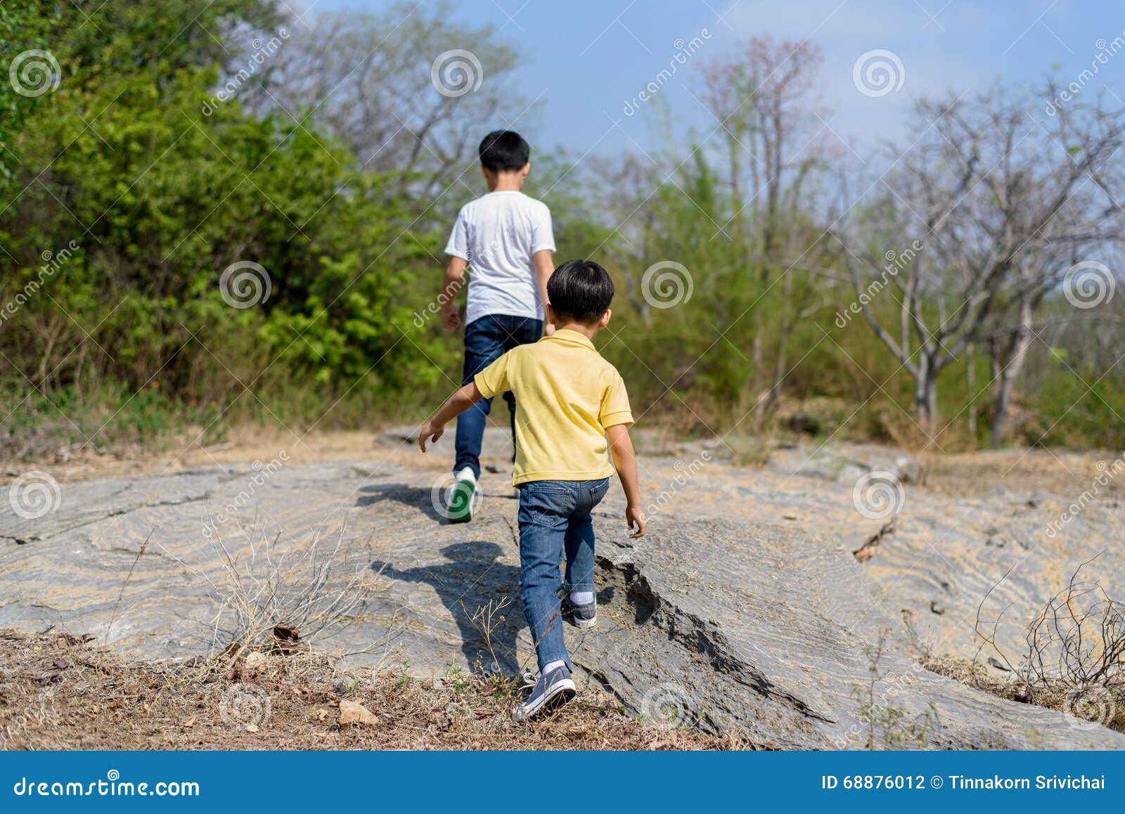 Two Boy Walking on the Rocky Land. Stock Photo - Image of grass, land: 68876012