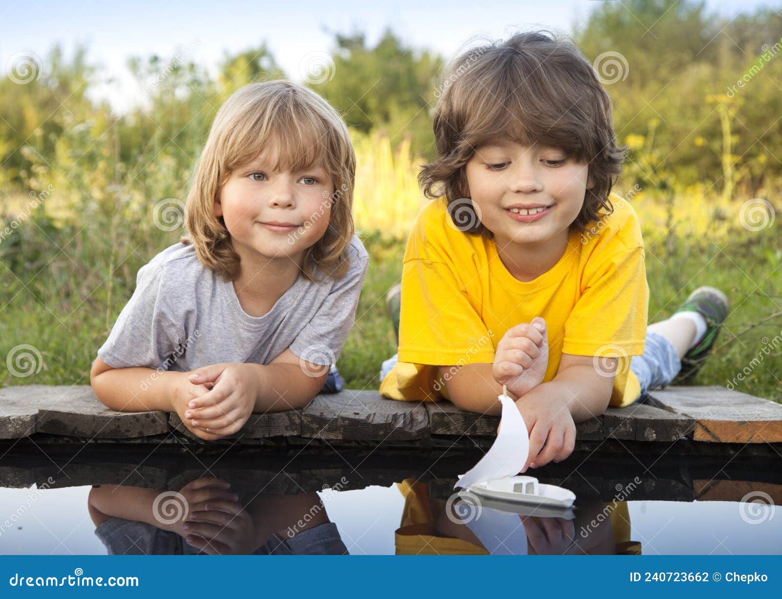 Two Boys Allowed Paper Boats from the Pier of the River Stock Photo ...