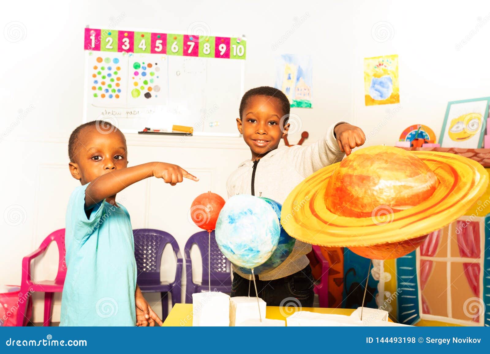 Two Boys in Early Development Class Show Planets Stock Photo - Image of ...
