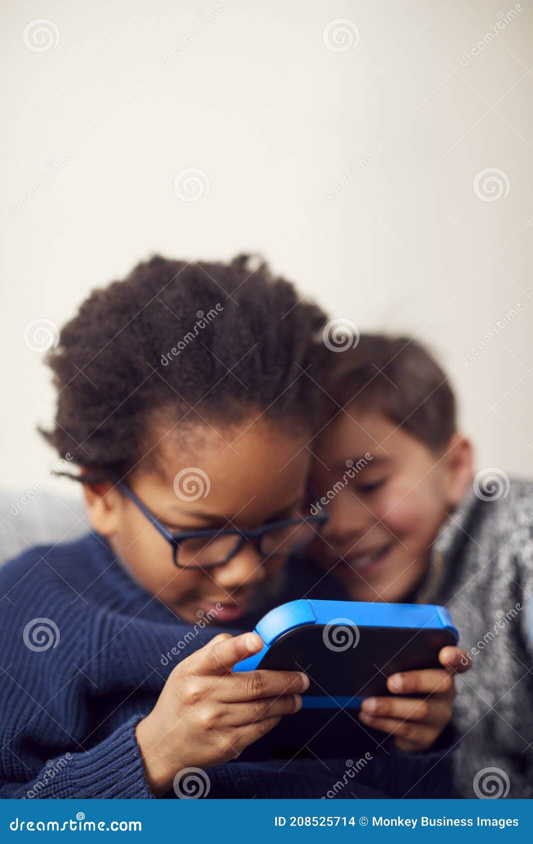 Two Boys Gaming Together on Hand Held Devices at Home Stock Photo ...