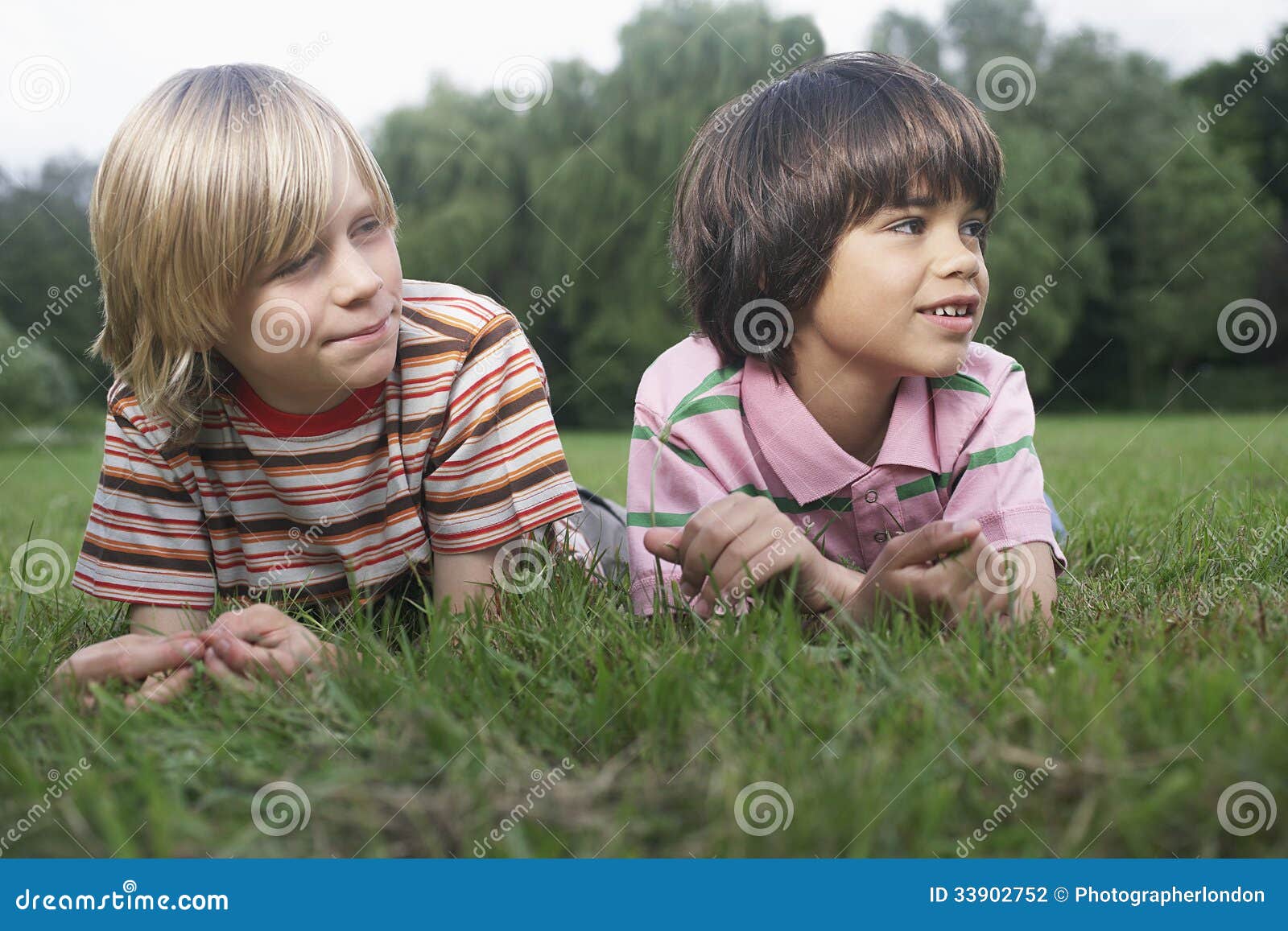 Two Boys Lying in Meadow stock photo. Image of friendship - 33902752