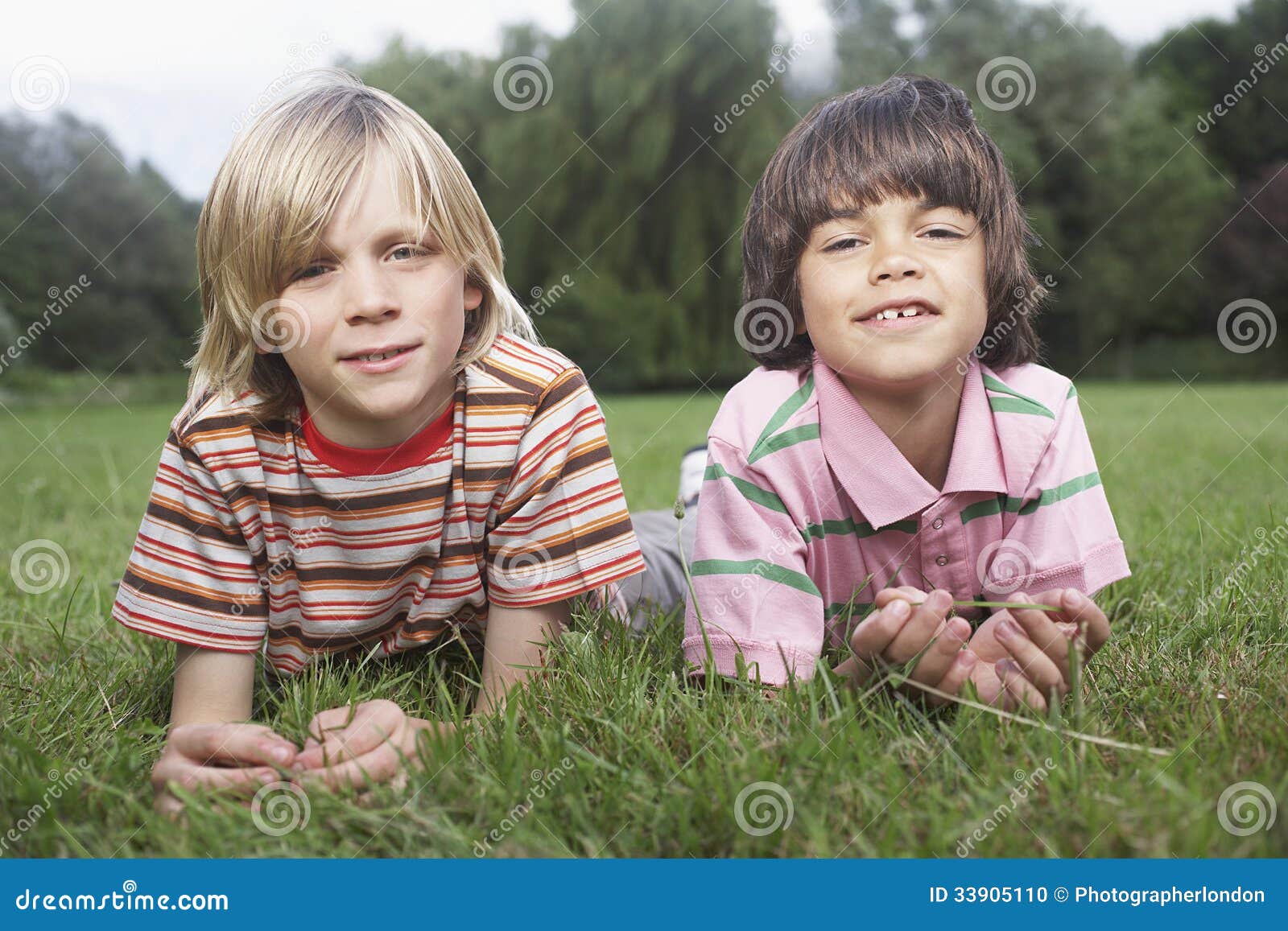 Two Boys Lying in Meadow stock photo. Image of striped - 33905110