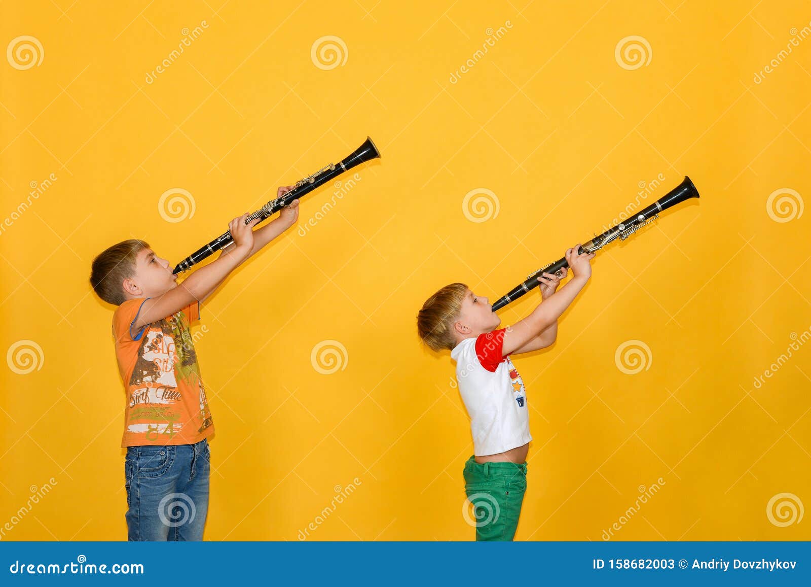 Two Boys Play the Clarinet and Hold it Up, on a Yellow Background Stock ...