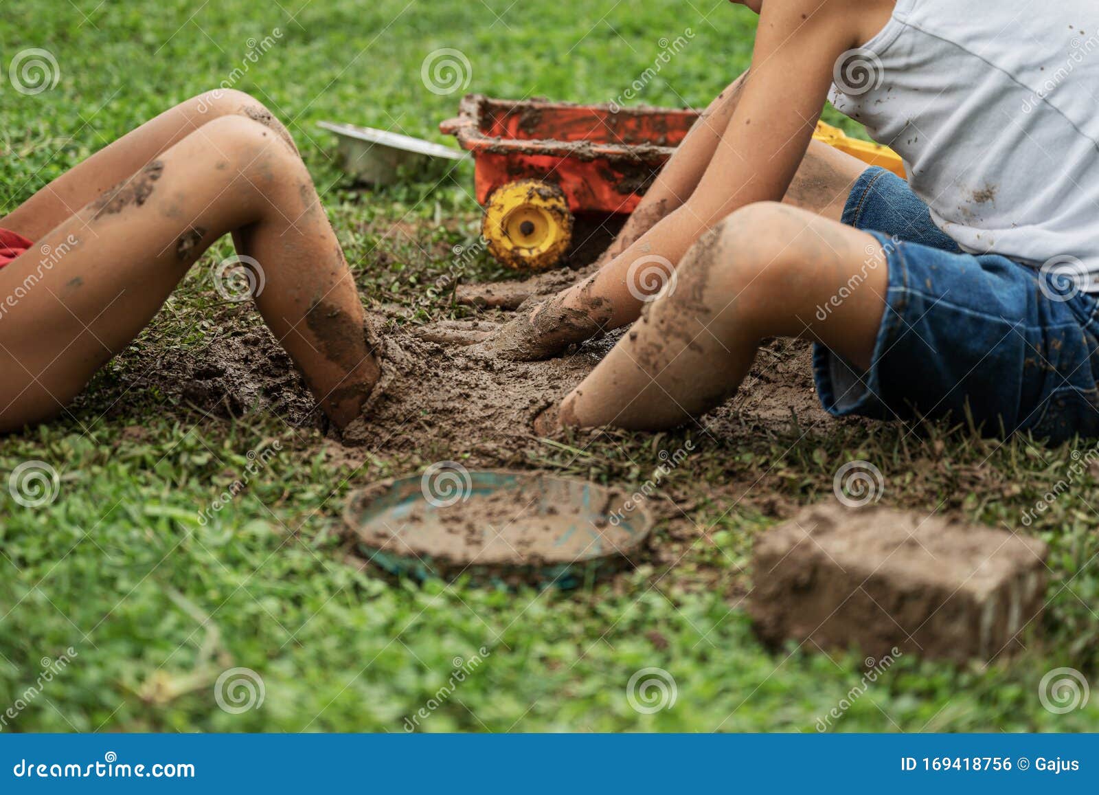 Boys playing with mud stock photo. Image of delight - 169418756