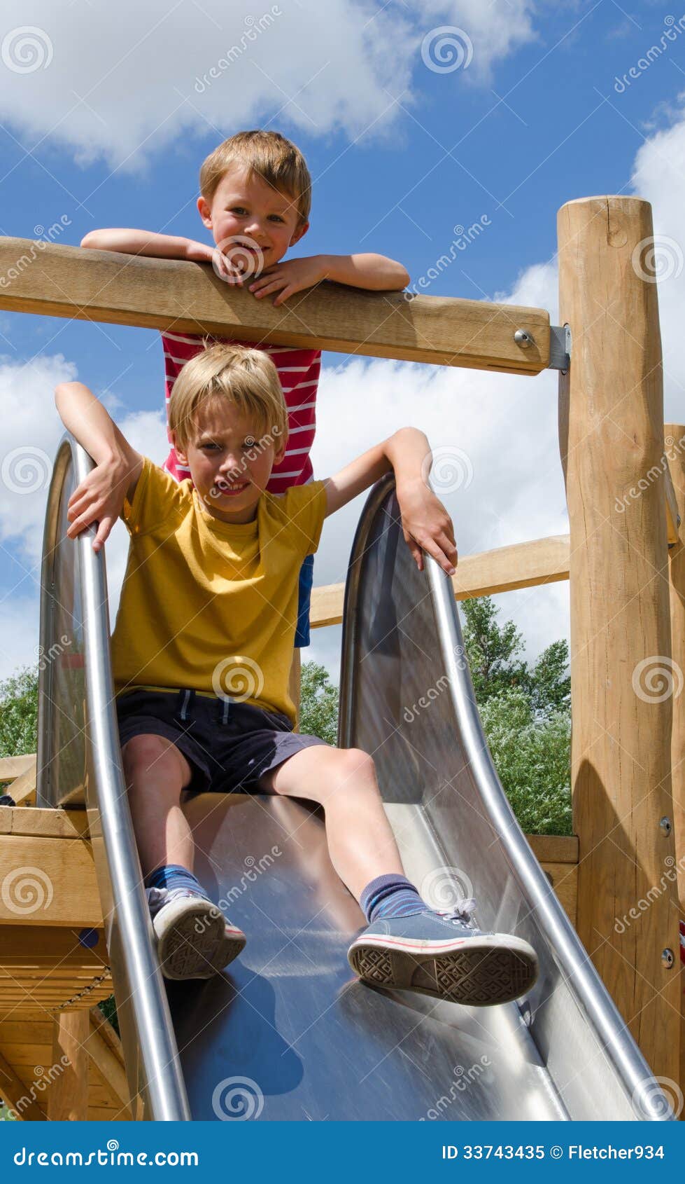 Two Boys Playing on a Slide Stock Image - Image of playing, male: 33743435