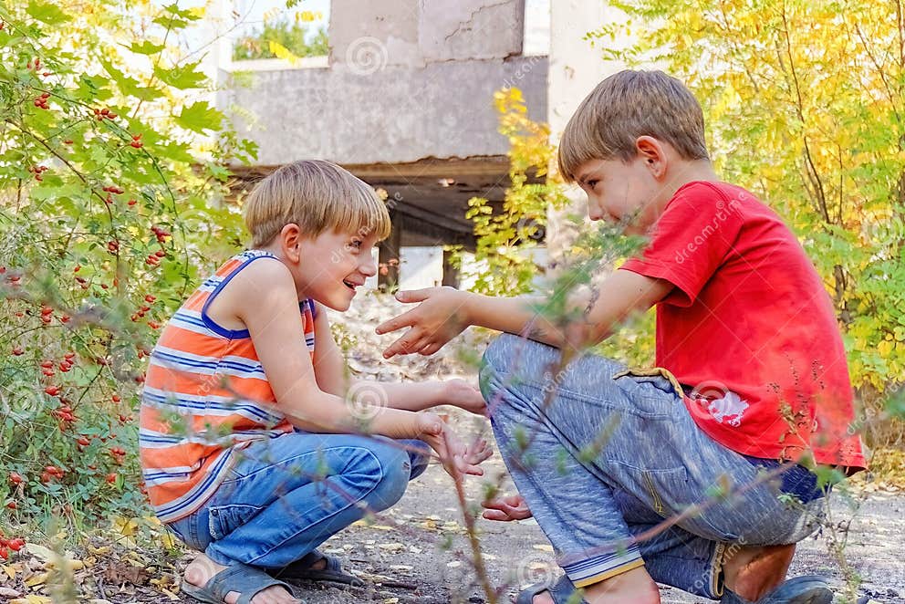 Two Boys Sit Opposite Each Other in the Park and Communicate with Each ...