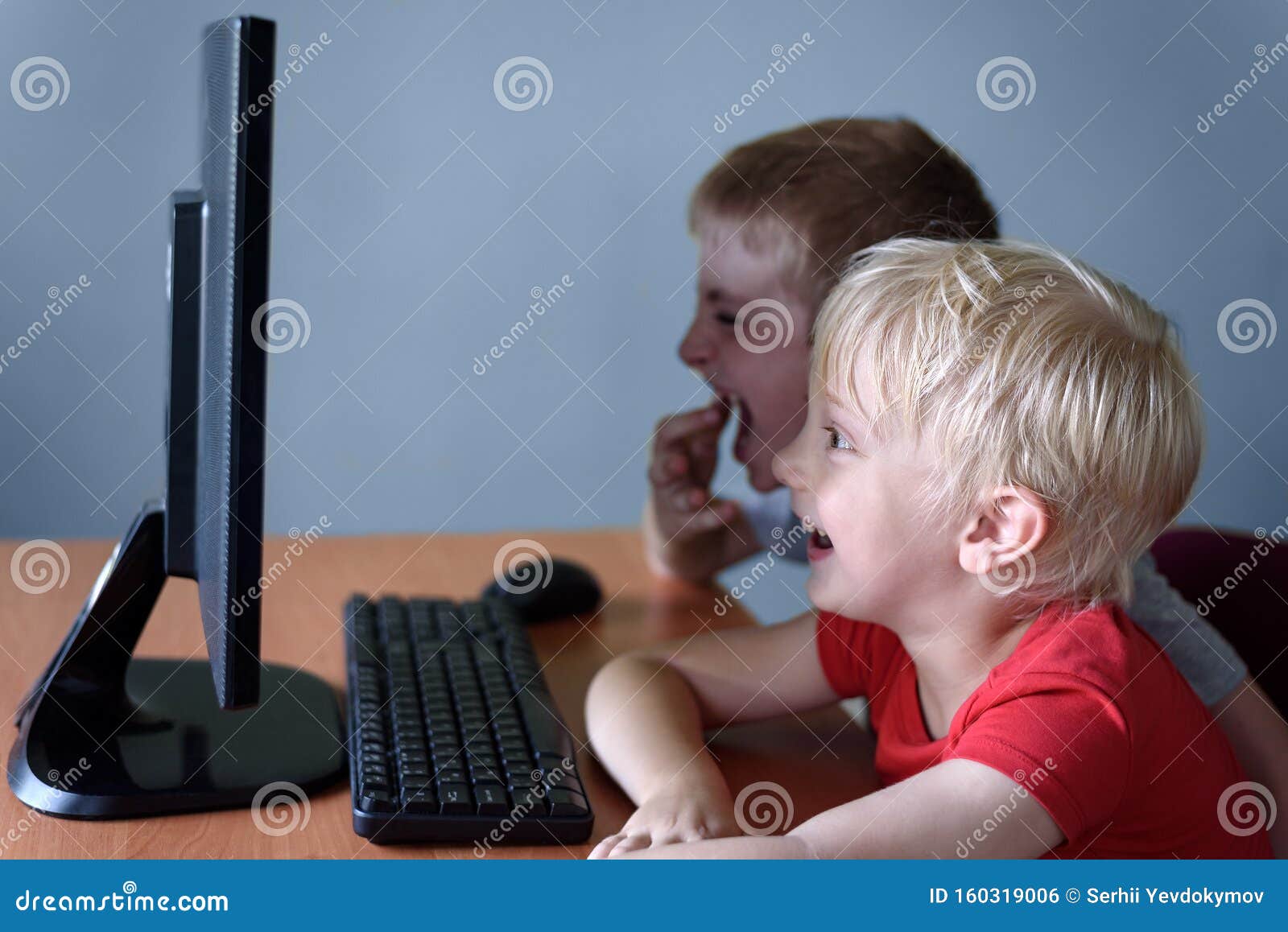 Two Boys are Watching Something on the Computer with a Laugh. Children ...