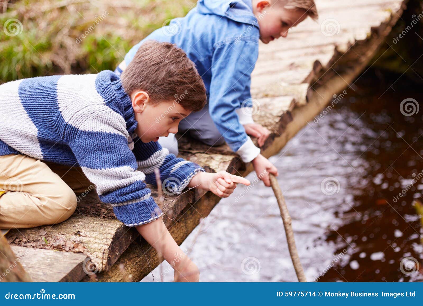 Two Boys on Wooden Bridge Playing with Sticks in Stream Stock Photo ...