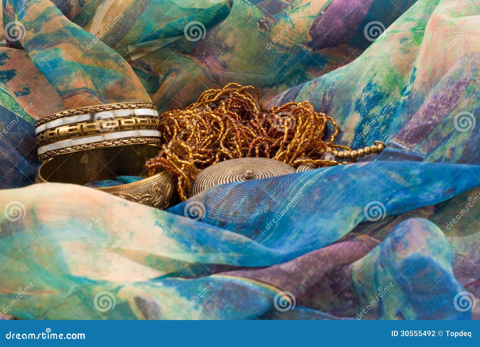 Two Bracelets and a Necklace on a Multicolored Silk Stock Photo - Image ...