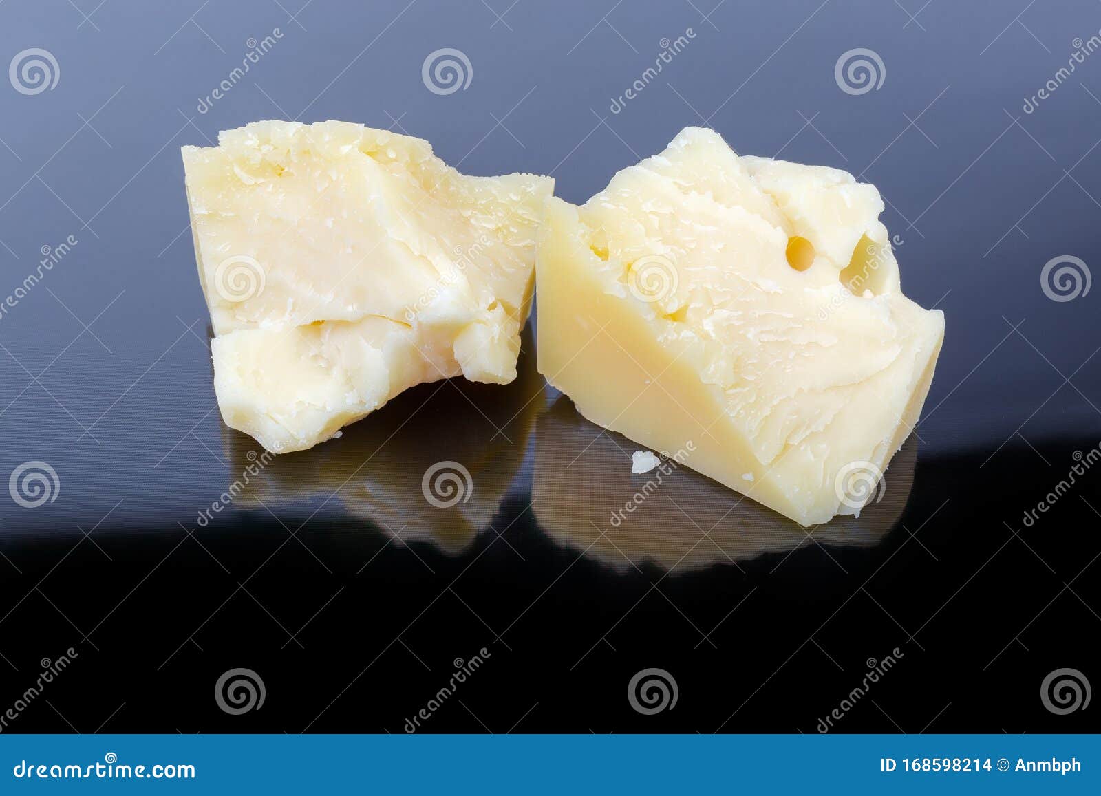 Two Broken Pieces of Hard Cheese on Dark Reflective Surface Stock Photo ...