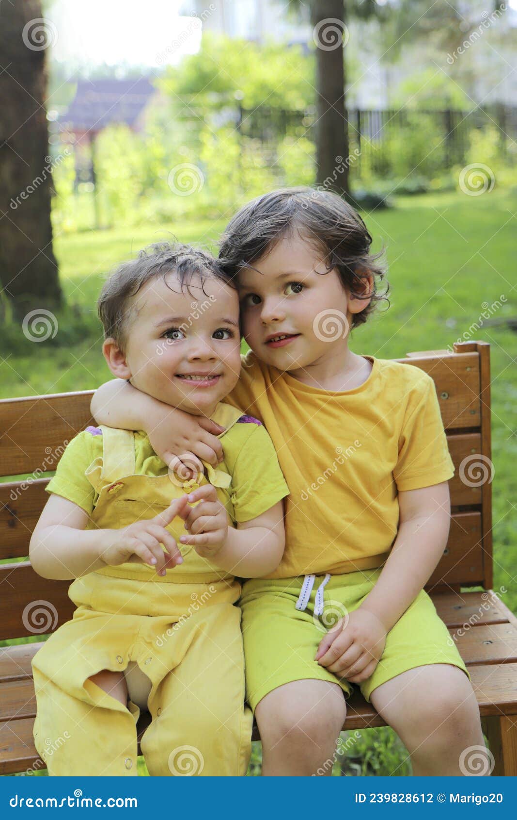 Two Brothers are Sitting on a Bench in the Summer. Stock Photo - Image ...