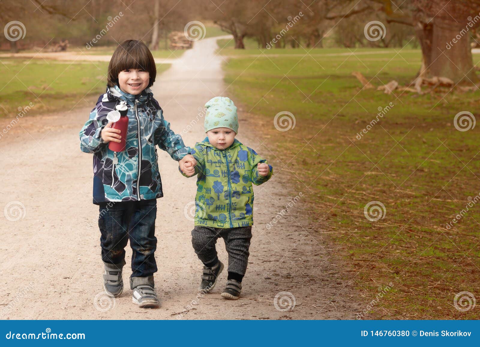 Two Brothers are Walking Hand in Hand in Park Stock Photo - Image of ...