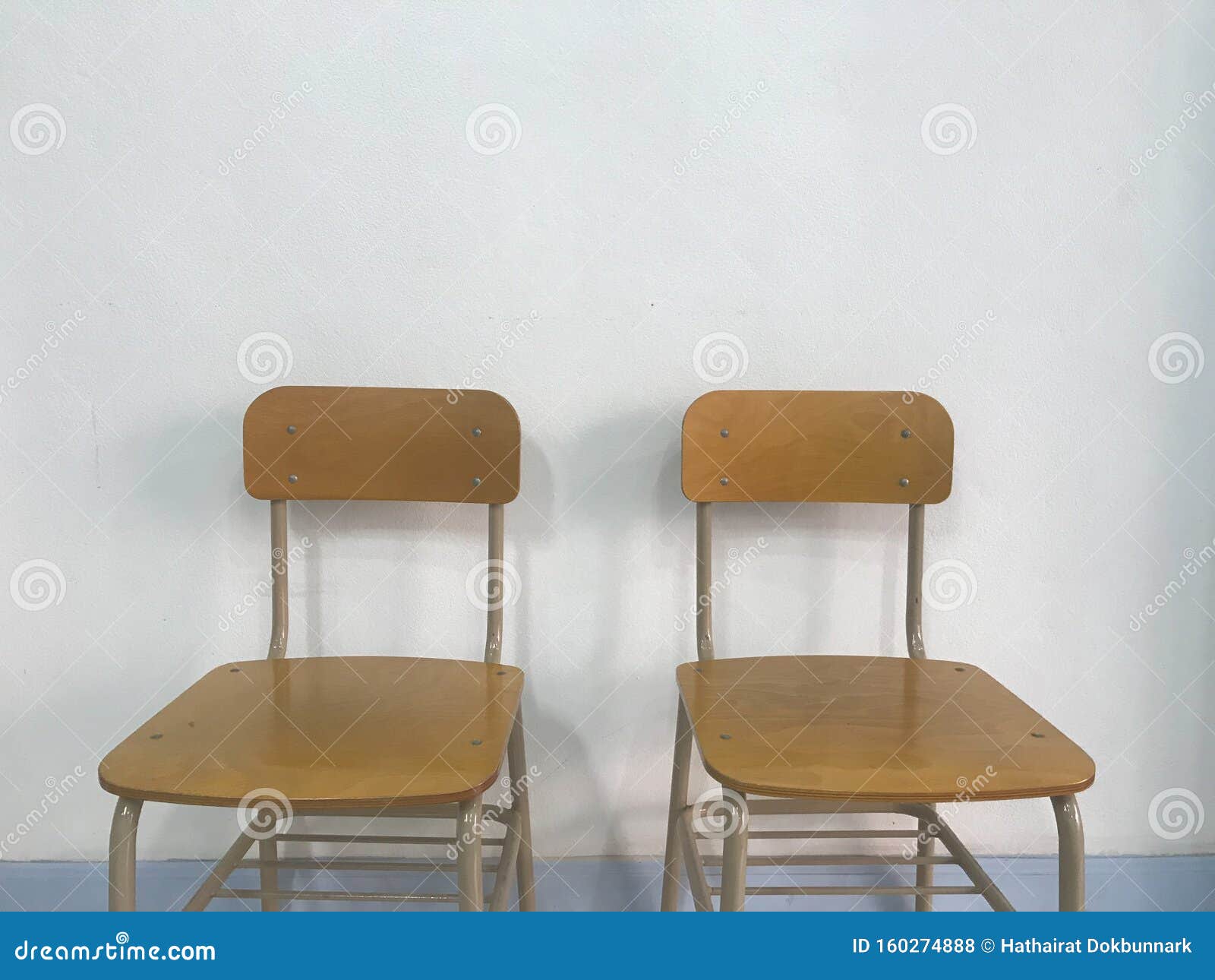Two Brown Empty School Chairs with White Wall Stock Photo - Image of ...