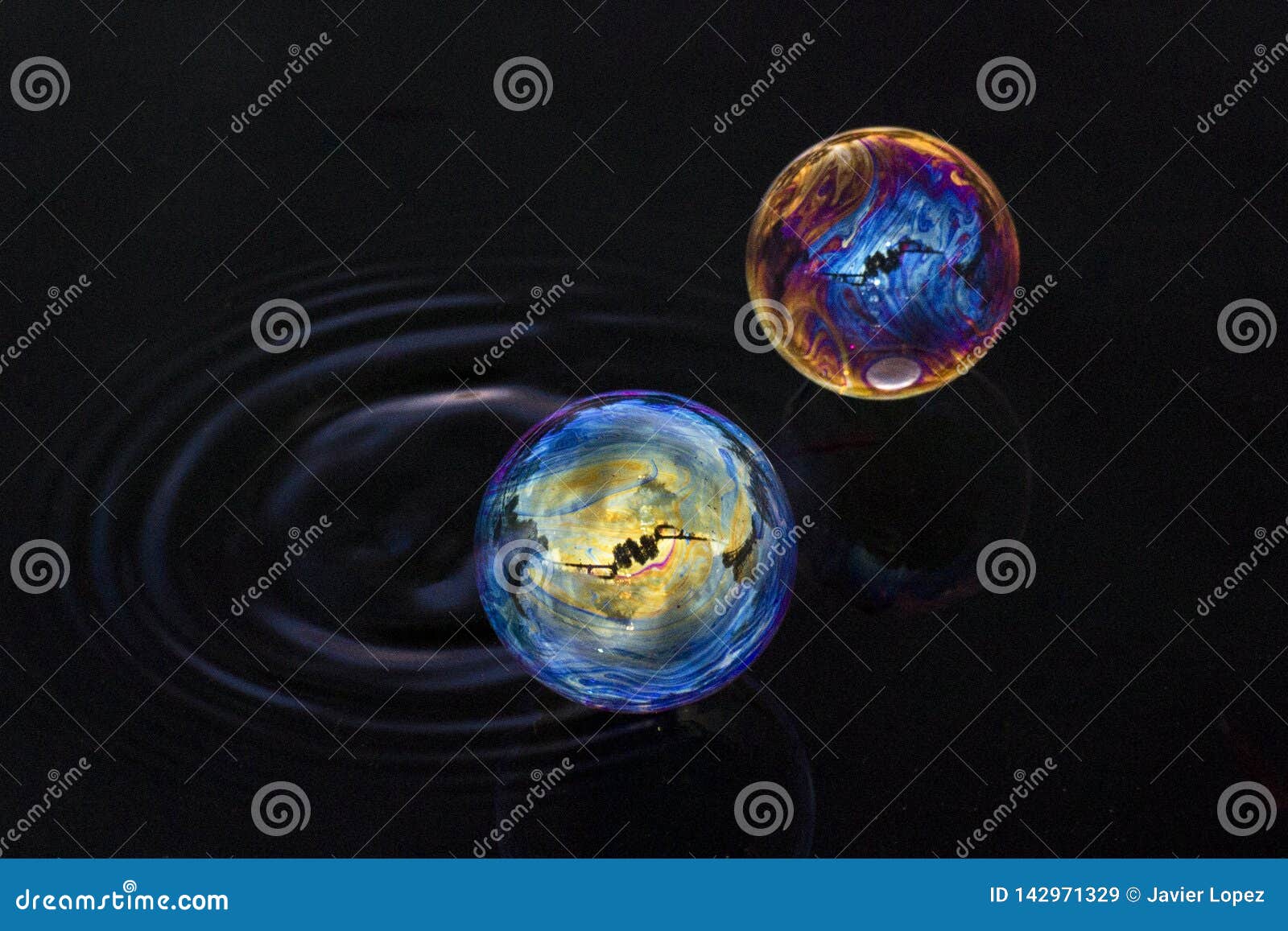Two Bubbles of Different Colors Floating Over the Water Stock ...