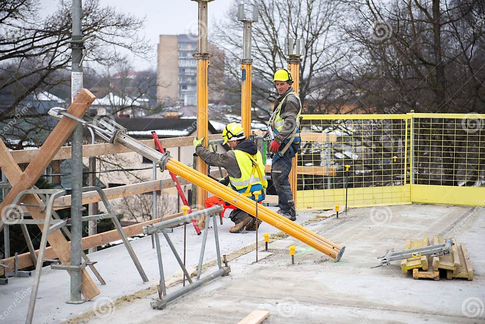 Two Builder Construction Workers in the Work Process on Building Site ...