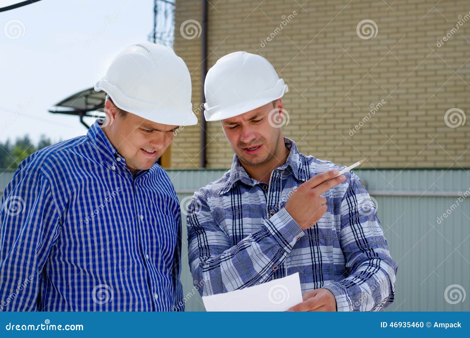 Two Builders or Engineers Discussing Paperwork Stock Photo - Image of ...