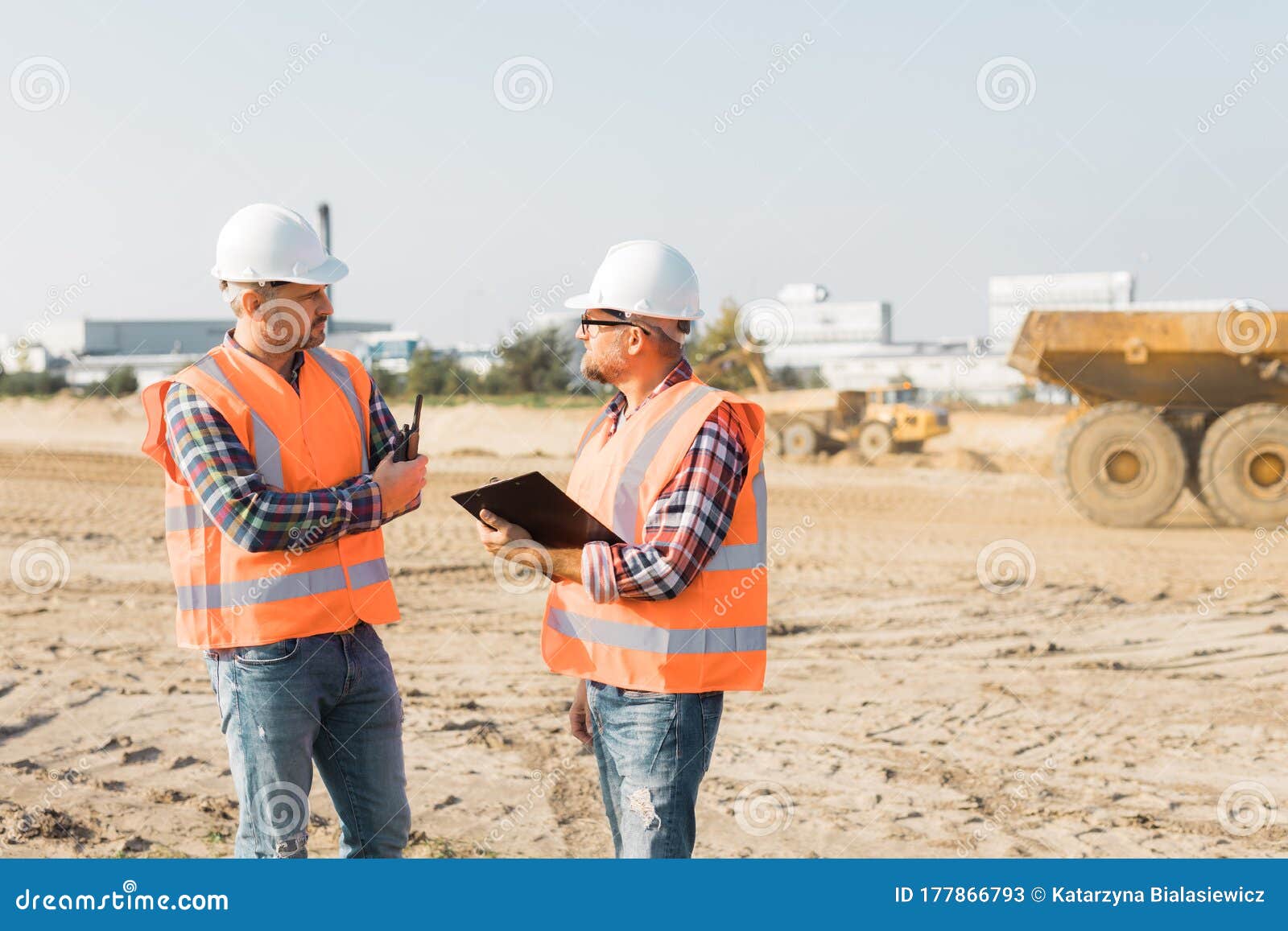 Builders in Orange Vests and Helmets Working on the Road Construction ...