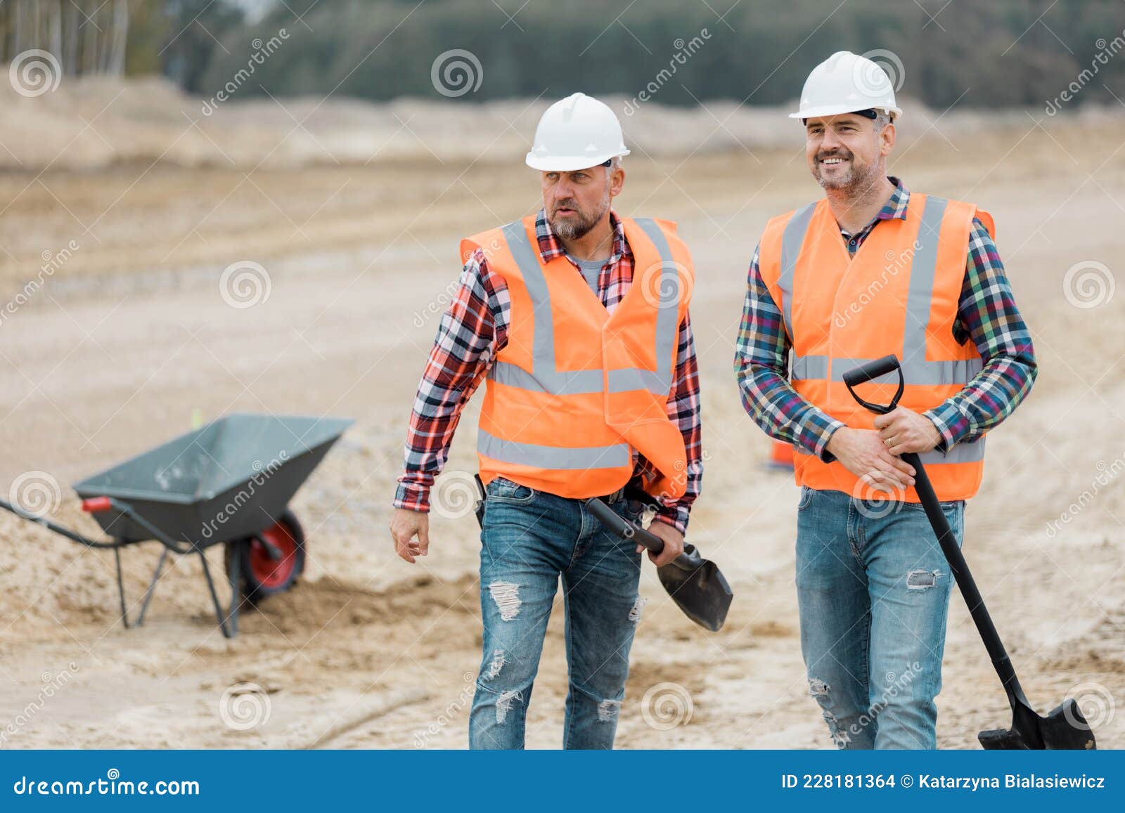 Builders in Orange Vests and Helmets Working on the Road Construction ...
