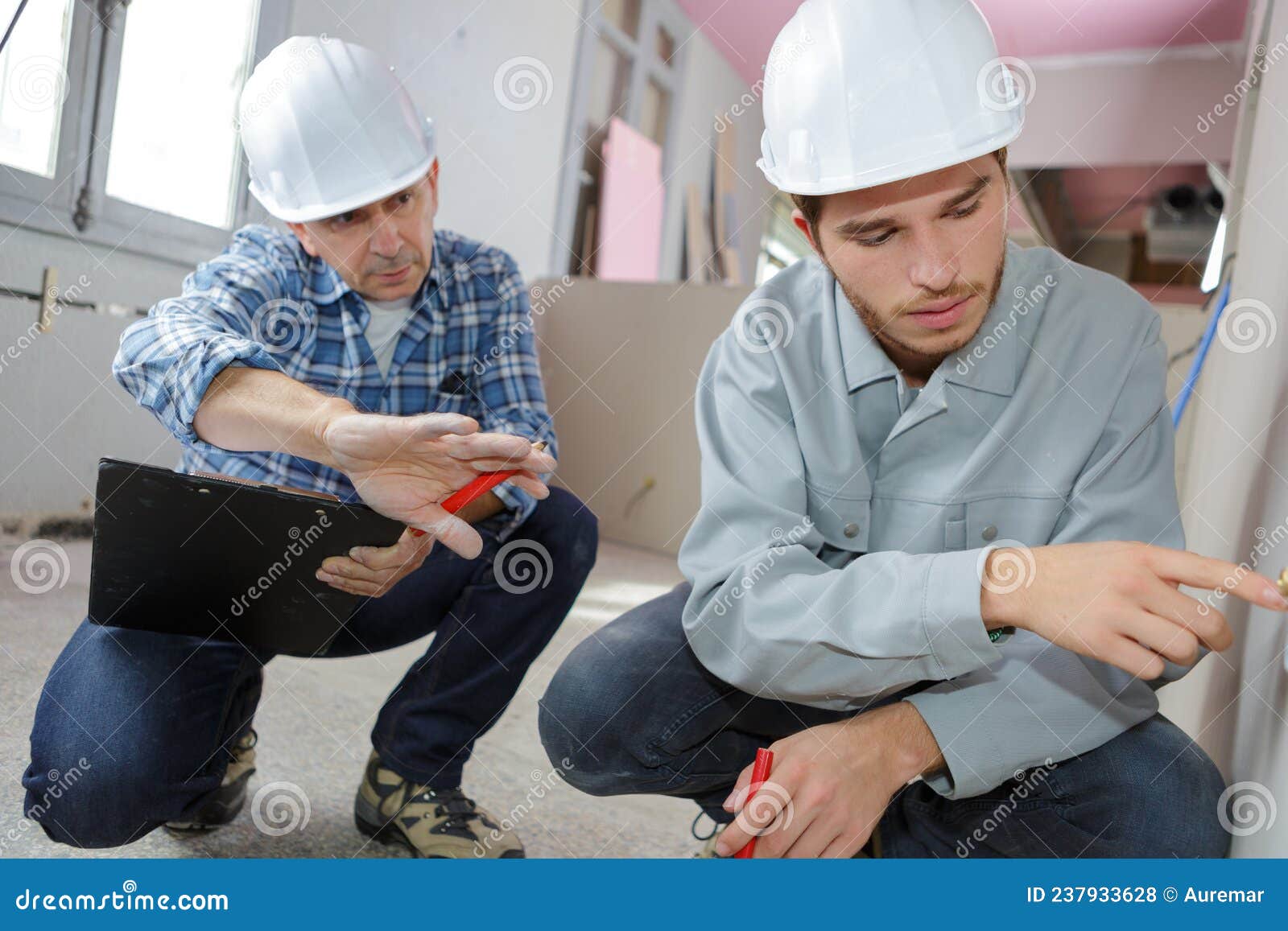 Two Builders Pointing at Wall Stock Photo - Image of business ...