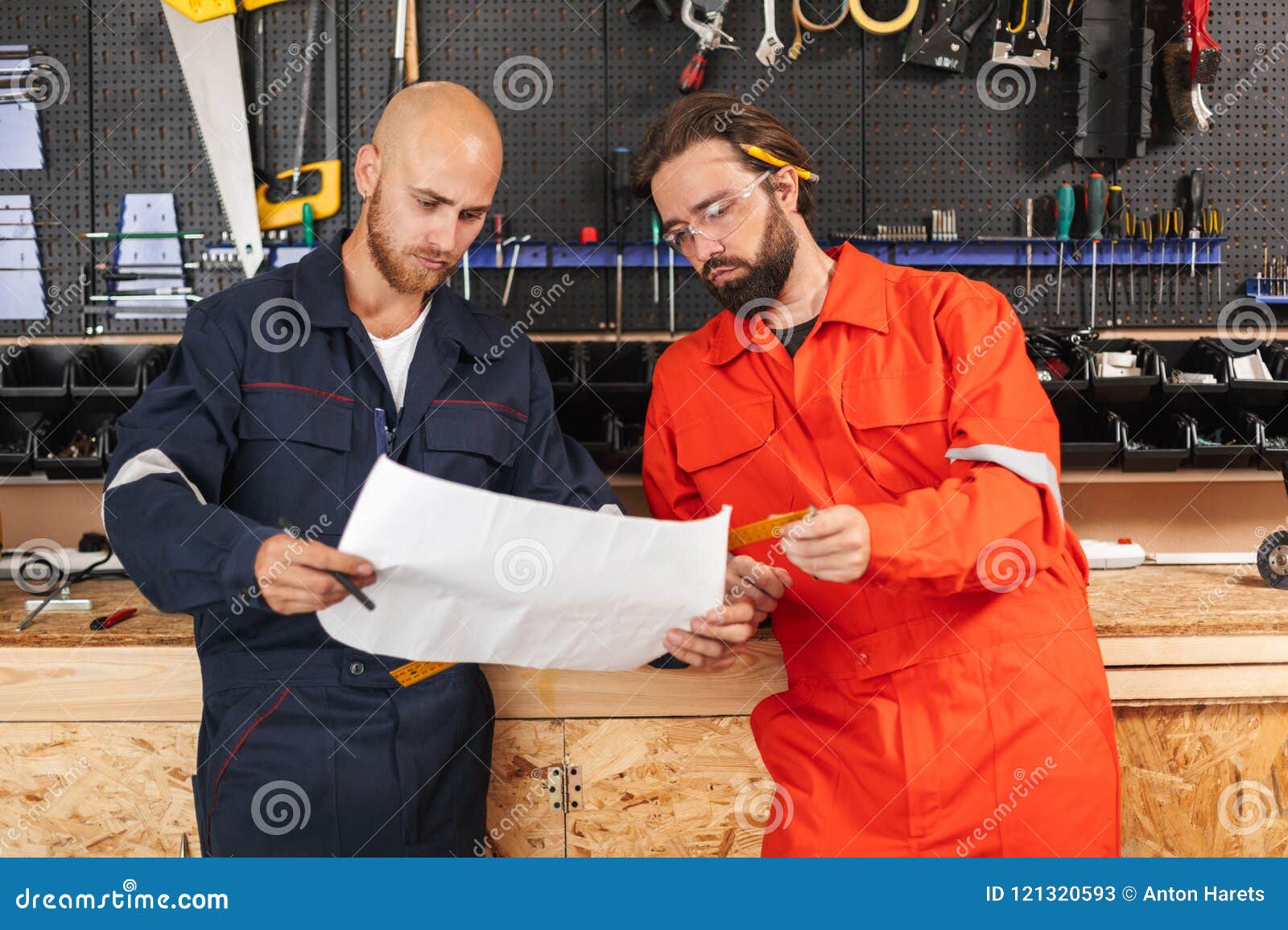 Two Builders in Work Clothes Thoughtfully Looking on Sketch with Stock ...