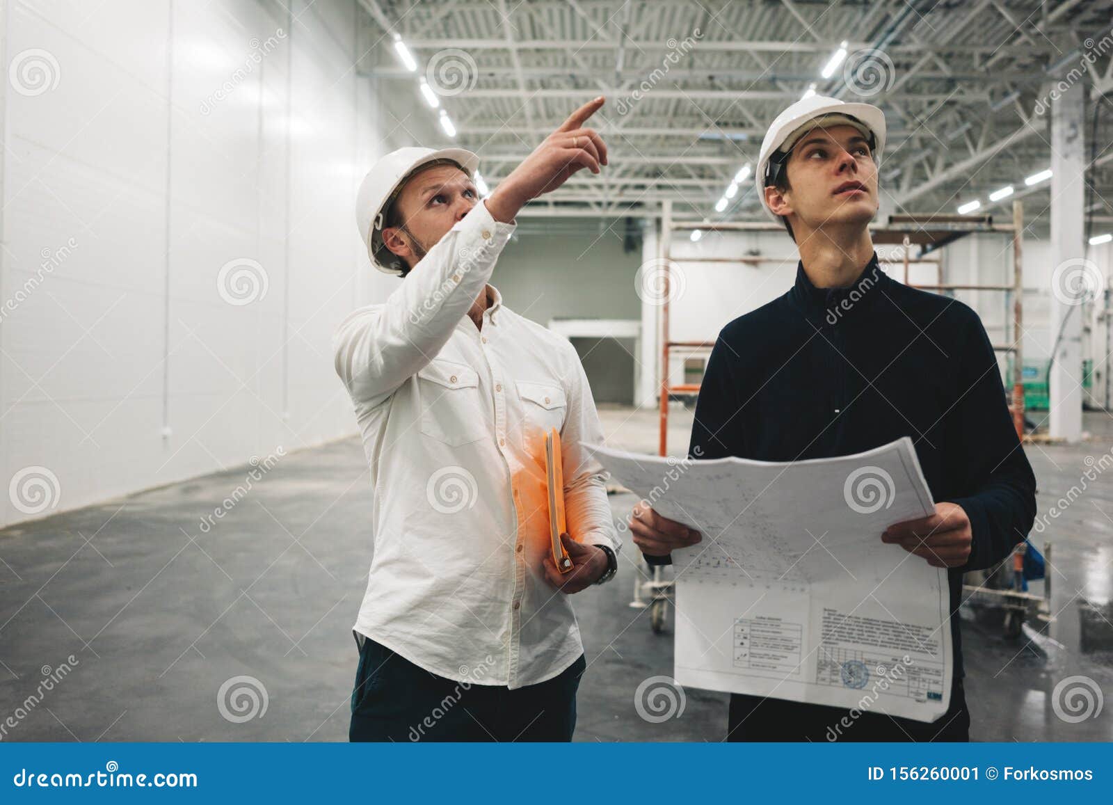Two Building Engineers with Blueprint Working on Construction Site ...