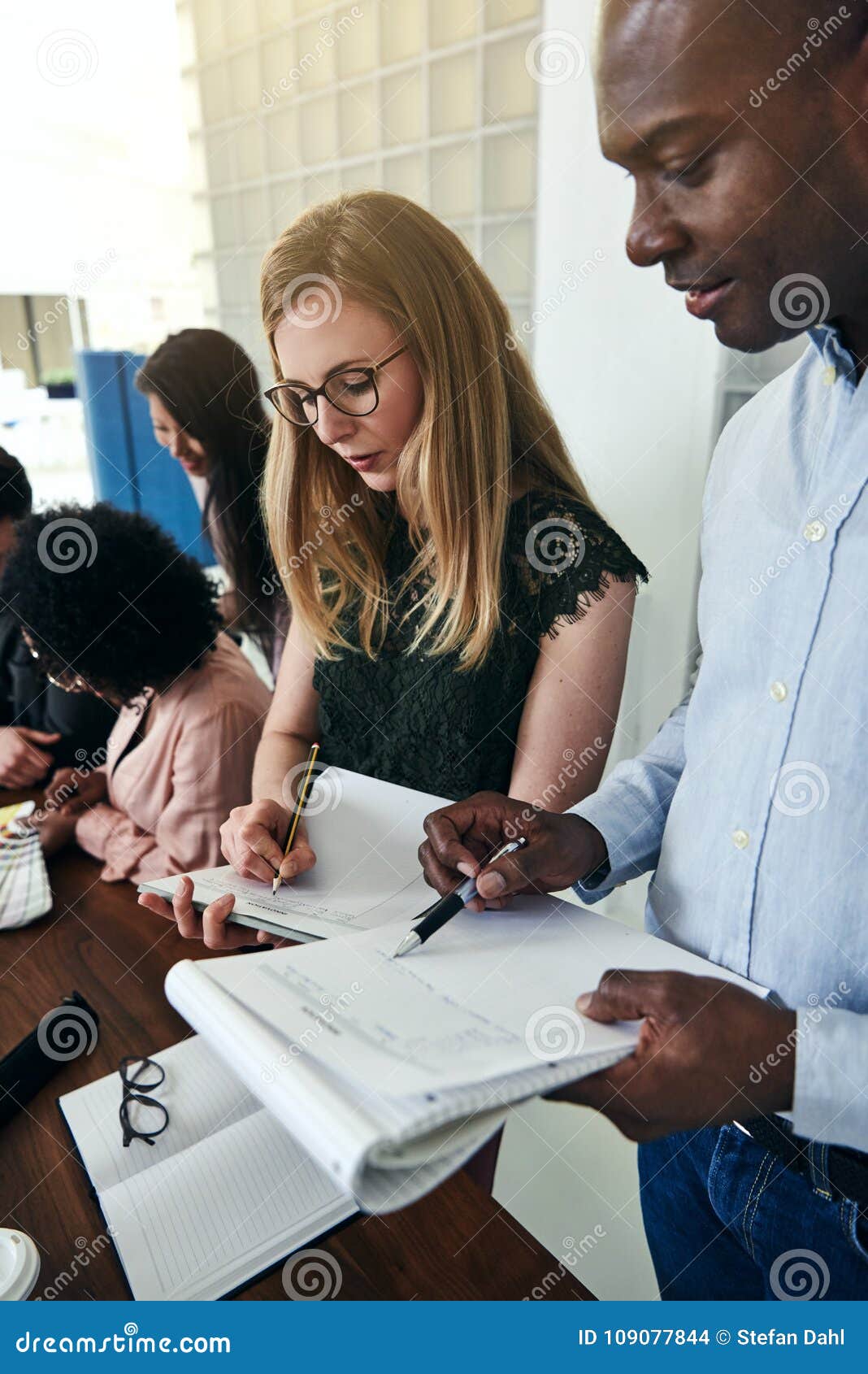 Two Business Colleagues Comparing Work Notes Together in an Office ...