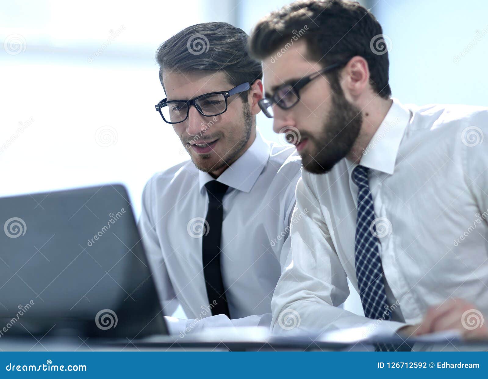 Two Business Colleagues are Discussing Something Sitting at the Desk ... Two Business Colleagues are Discussing Something Sitting at the Desk ...