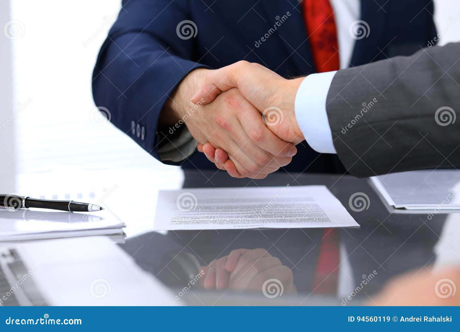 Two Business Man Shaking Hands To Each Other Above Signed Contract ...