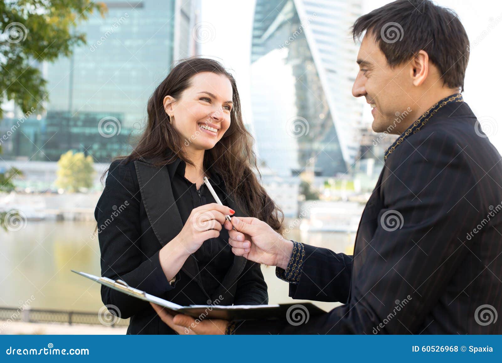 Two Business People Looking at Papers Stock Photo - Image of outdoors ...