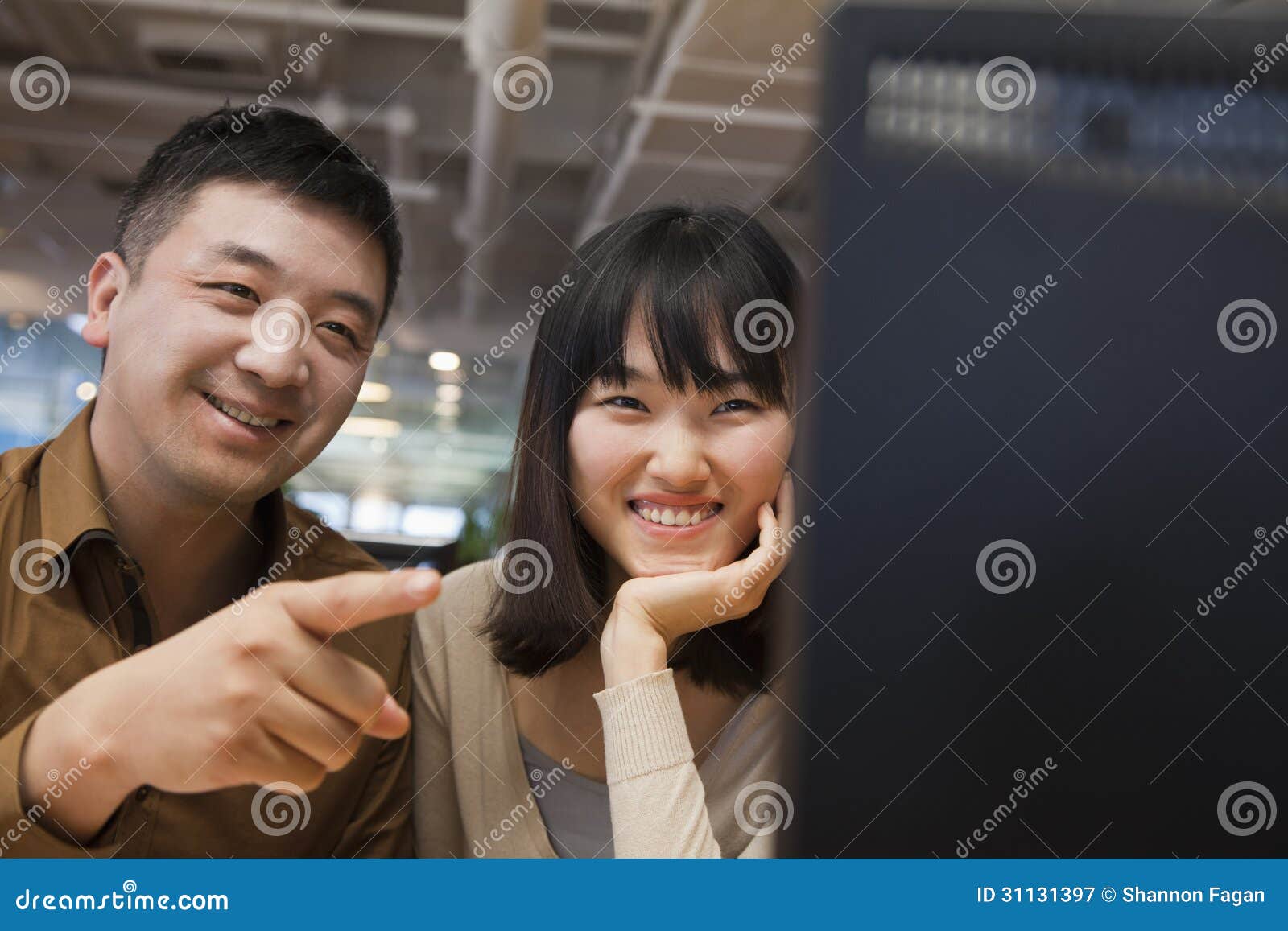 Two Business People Smiling and Looking at Computer in the Office Stock ...
