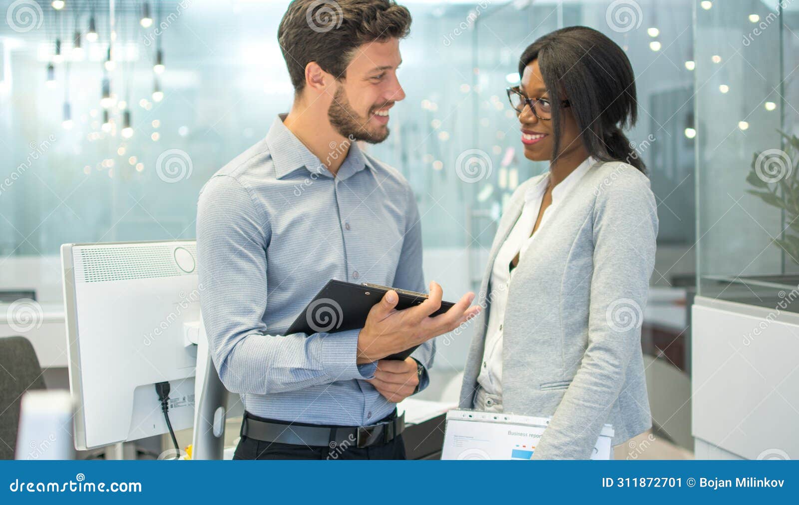 Two Business People Talking and Smiling To Each Other in Modern Office ... Two Business People Talking and Smiling To Each Other in Modern Office ...