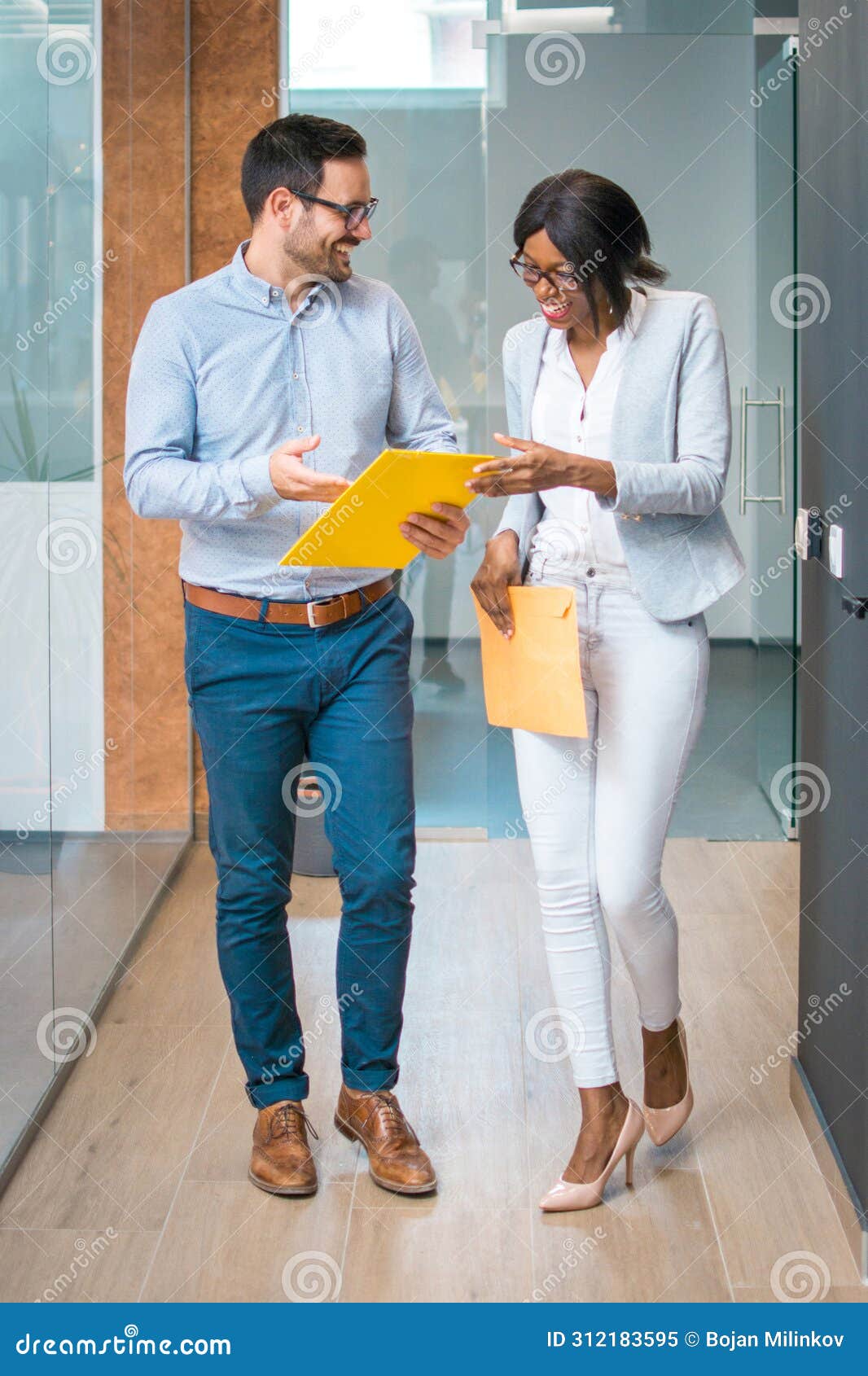 Two Business People Walking and Discussing Paperwork Indoors. Stock ...