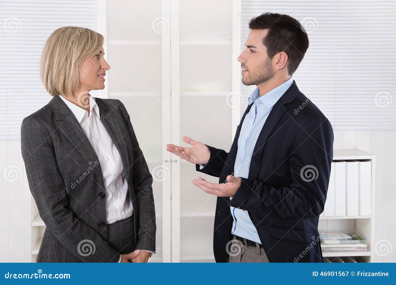 Two Business People Working in a Team Talking Together in the of Stock ...