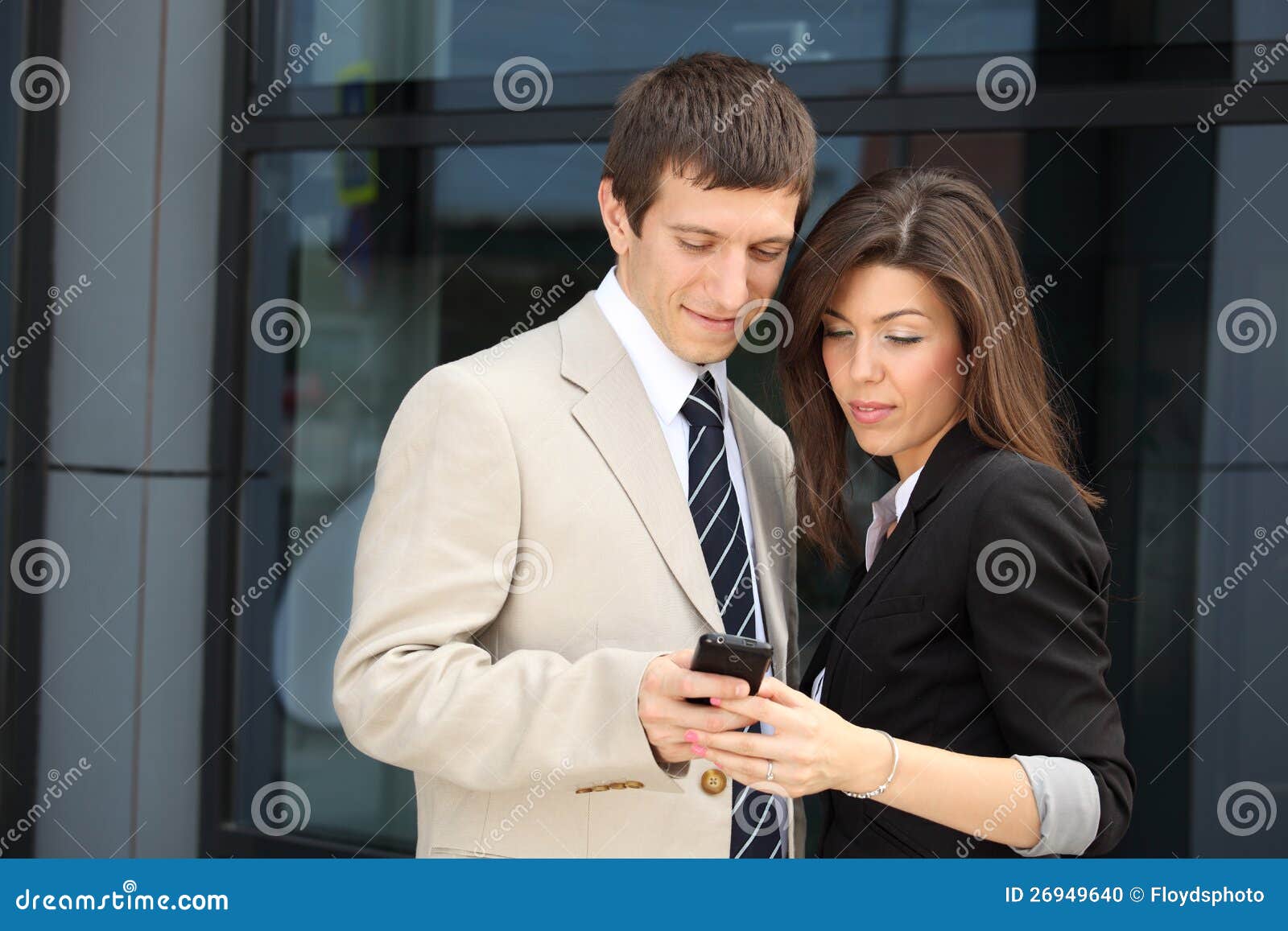 Two Business Persons Watching a Mobile Phone Stock Photo - Image of ...
