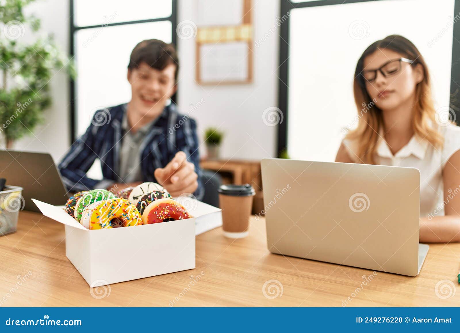 Two Business Workers Smiling Happy Eating Doughnuts at the Office Stock ...