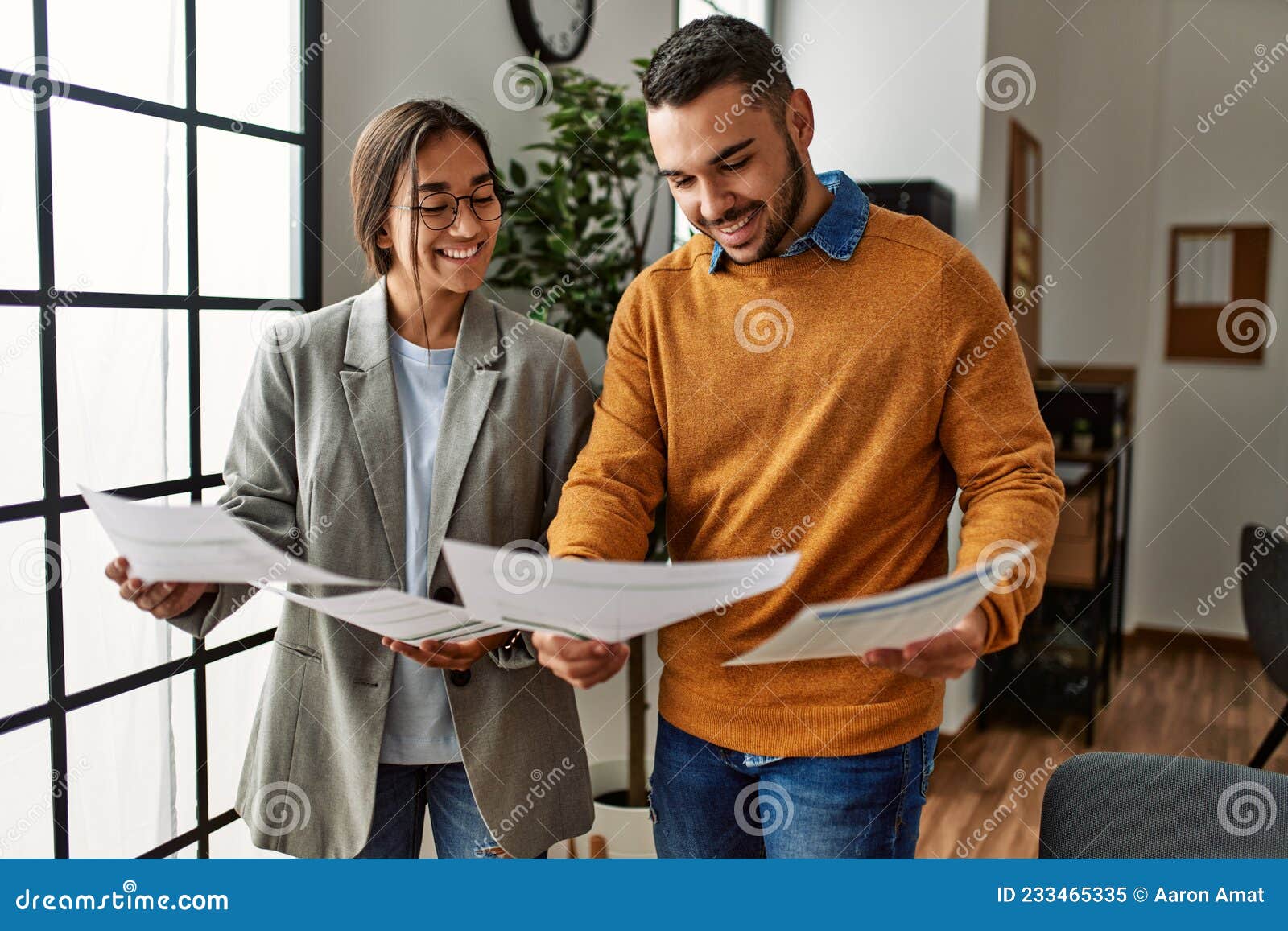Two Business Workers Smiling Happy Reading Paperwork Standing at the ...
