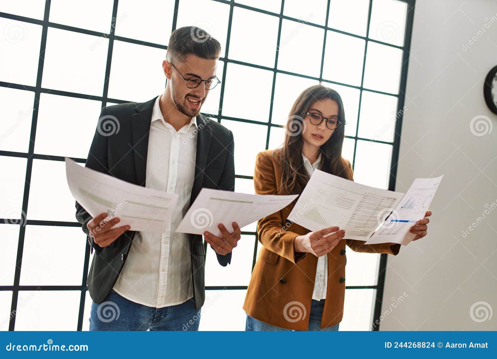 Two Business Workers Smiling Happy Reading Paperwork Standing at the ...
