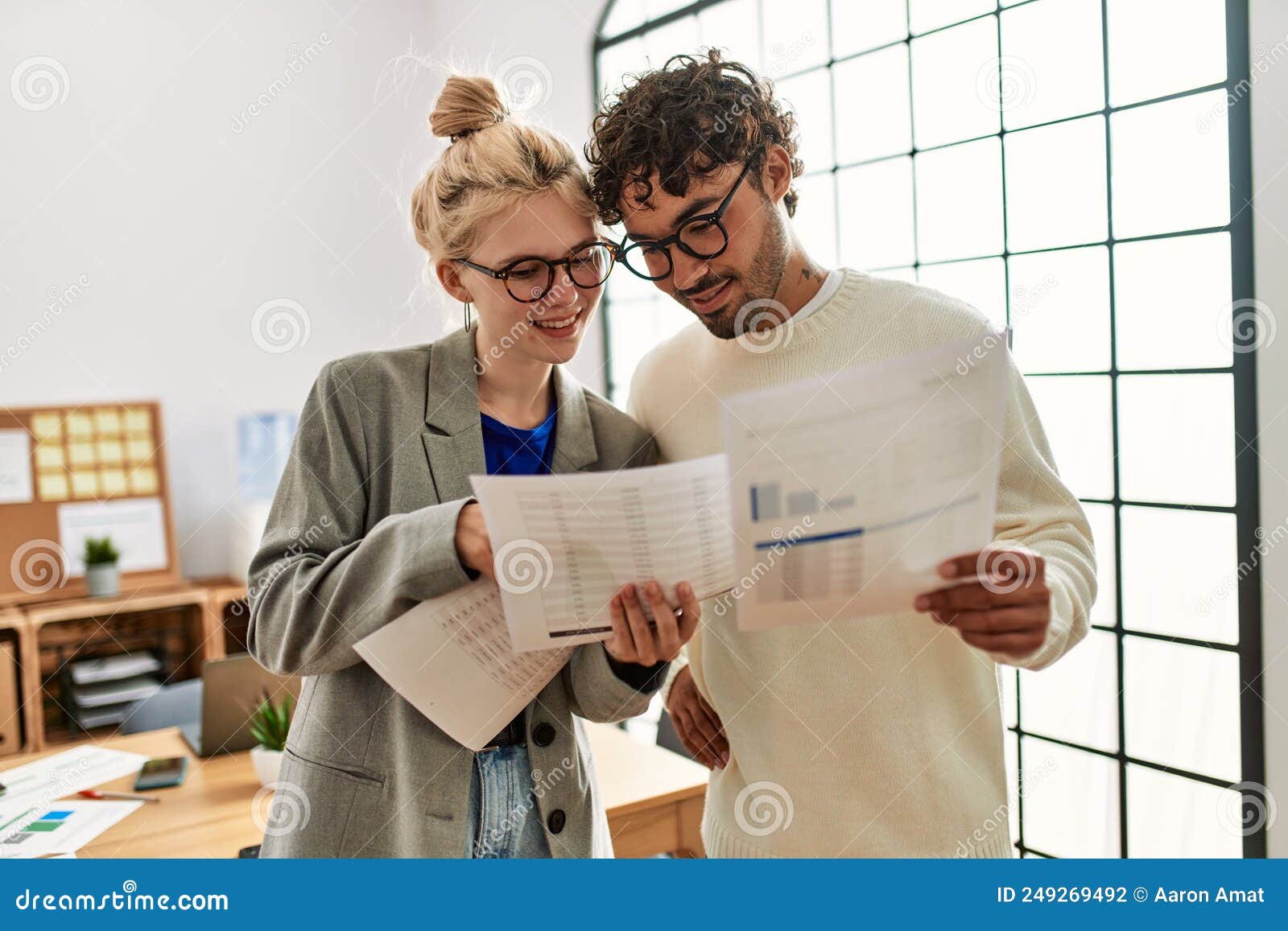 Two Business Workers Smiling Happy Reading Paperwork Standing at the ...